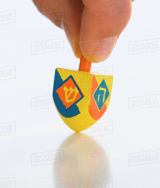 Close up of man spinning dreidel - Royalty-free Stock Photo | Dissolve