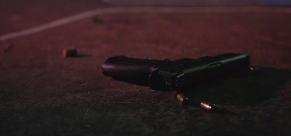 Close-up shot of a gun with cartridge near chalk outline of body of ...