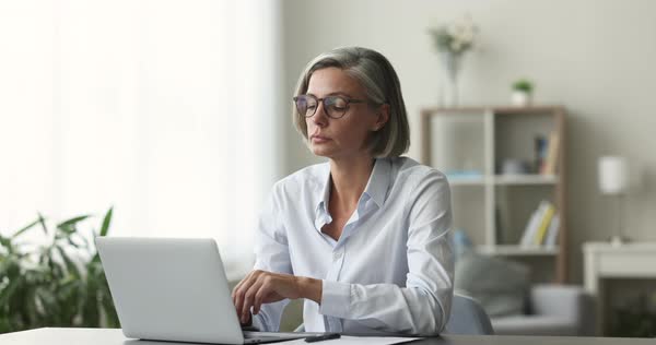 Serious business woman sit at desk use laptop lead correspondence - 4K Royalty-free Stock Video ...