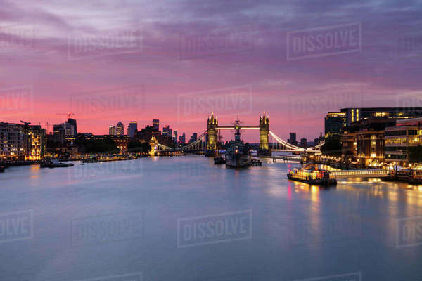 Tower Bridge, HMS Belfast, River Thames and Canary Wharf skyline at sunrise, London, England ...