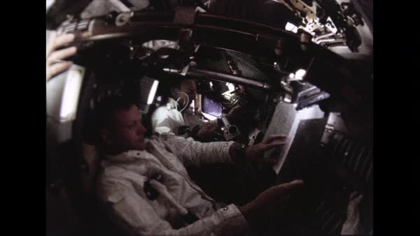 Commander Neil Armstrong floats in his couch inside the Command Module ...