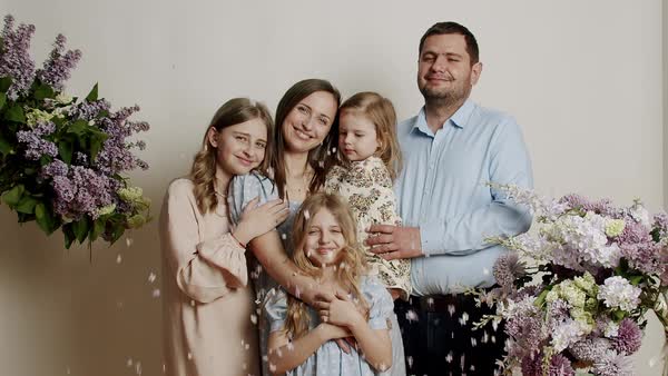 Family portrait standing for photo inside on a white background with ...