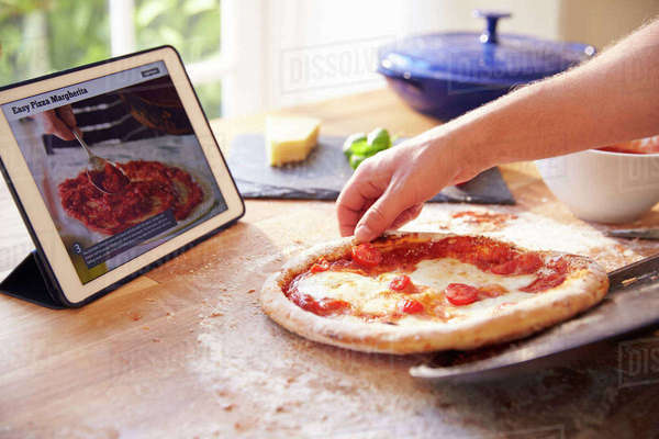 Person following pizza recipe using app on digital tablet - Royalty ...