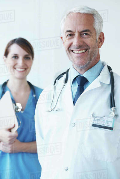 Happy, portrait and senior doctor with nurse in hospital with clipboard ...