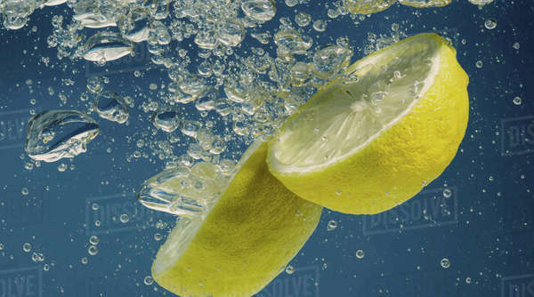 Underwater lemon slice in soda water or lemonade with bubbles. Refreshing soda tonic fizzy ...