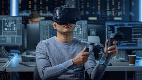 Portrait of Software Delevoper Wearing Virtual Reality Headset Using Controllers to Develop and ...