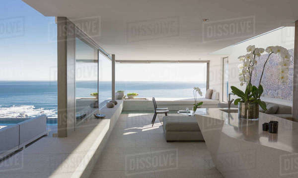 Modern, luxury home showcase interior living room with sunny ocean view ...