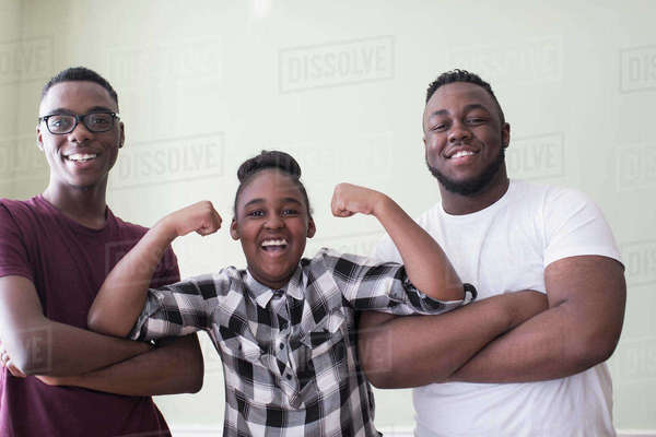 Portrait confident teenage brothers and sister flexing muscles - Stock ...