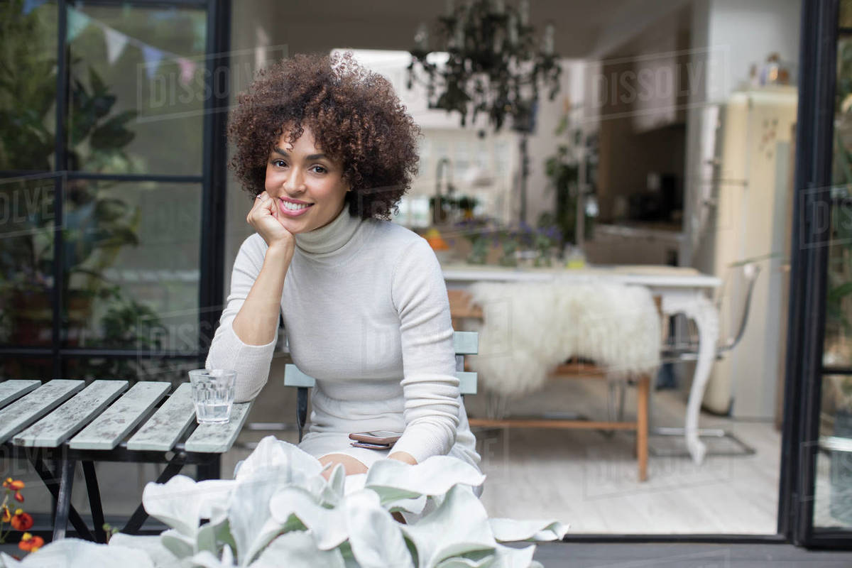 Portrait happy young woman on patio - Royalty-free Stock Photo | Dissolve