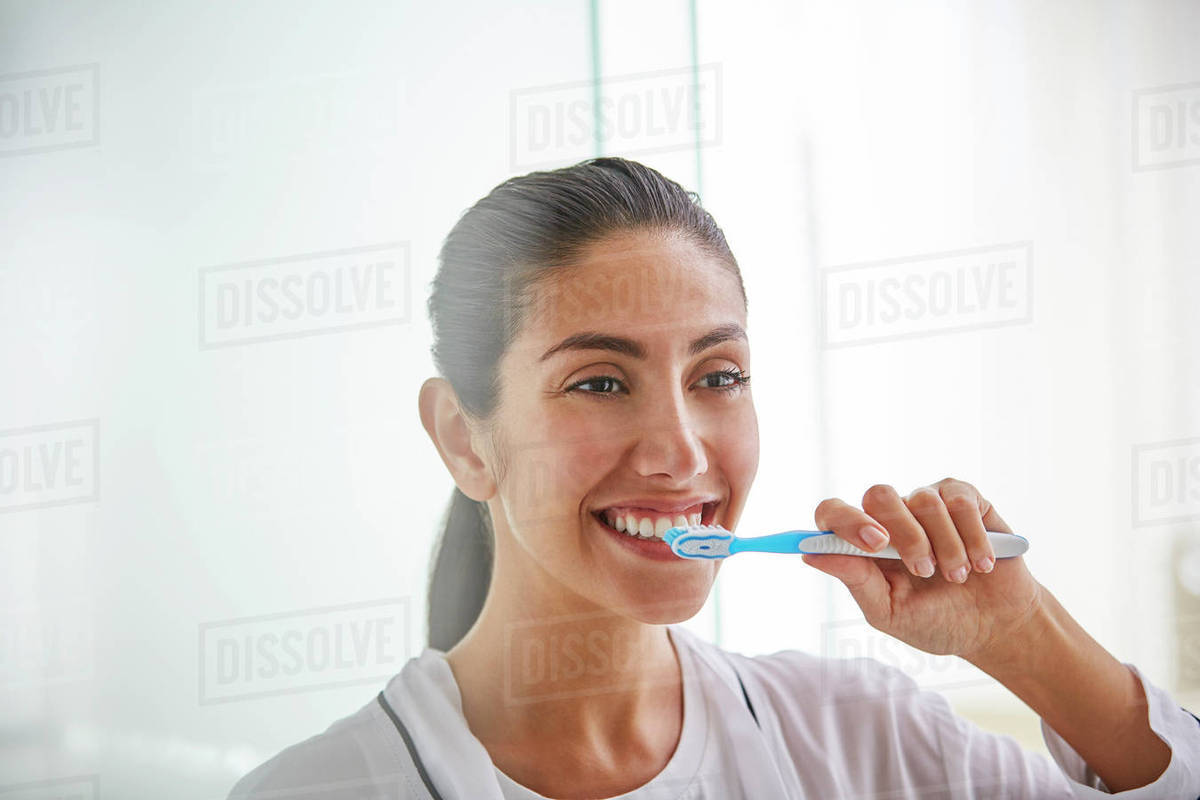 Woman brushing teeth with toothbrush - Stock Photo - Dissolve