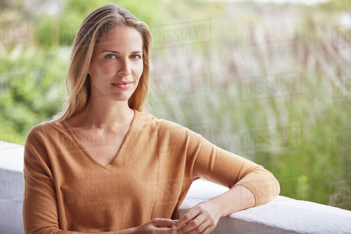 Portrait serene woman on patio - Royalty-free Stock Photo | Dissolve