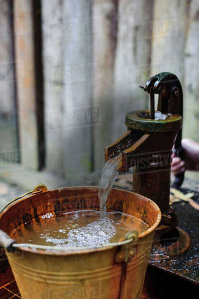 Water from water pump pouring into bucket - Royalty-free Stock Photo ...