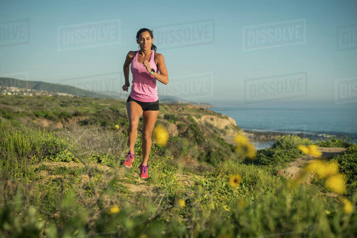 USA, California, Newport Beach, Woman running along cliff - Royalty ...