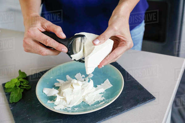 Hands of woman shaving cheese - Stock Photo - Dissolve