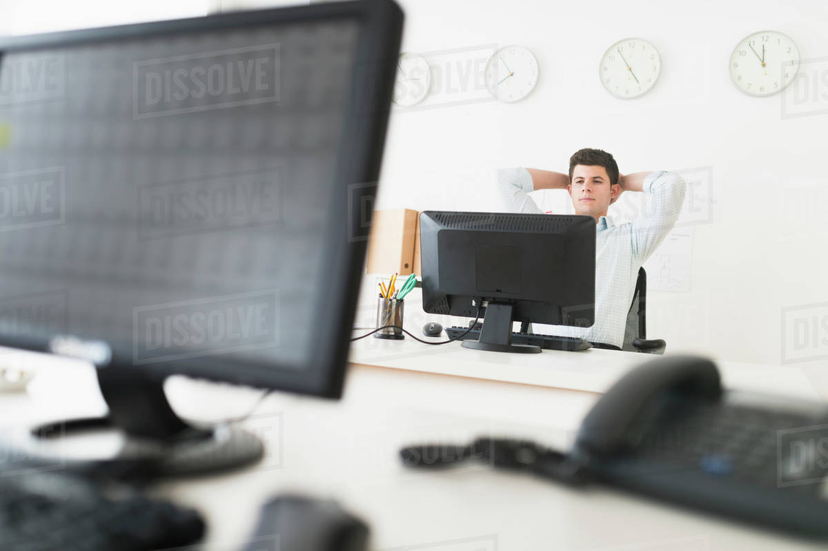 Young man sitting in front of desk and working - Royalty-free Stock ...