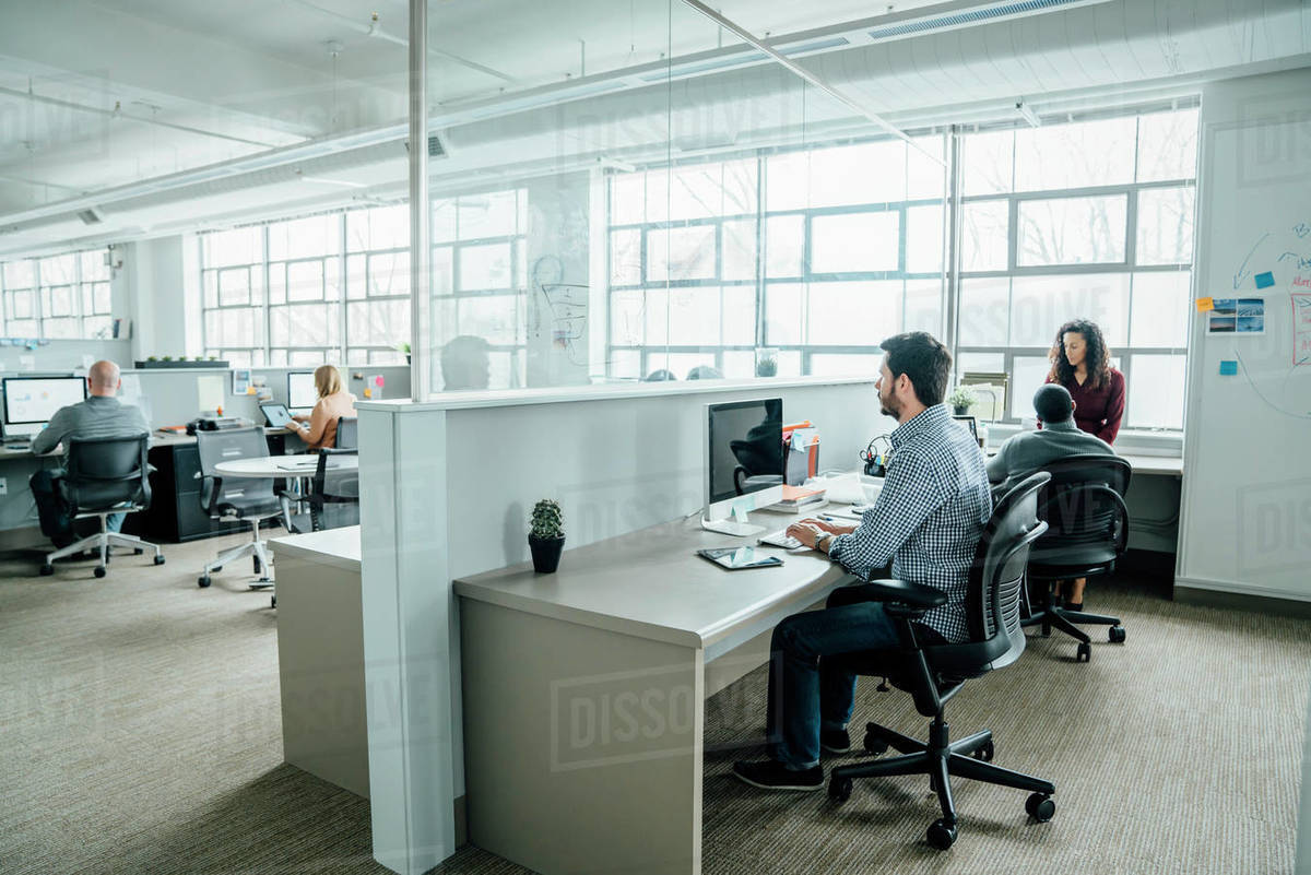 Workers using computers in office - Royalty-free Stock Photo | Dissolve