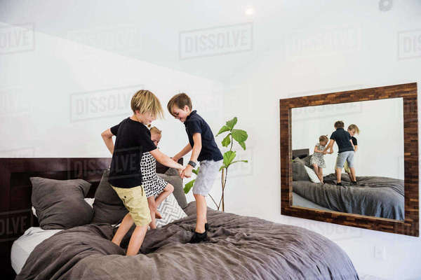 Children jumping on bed - Royalty-free Stock Photo | Dissolve