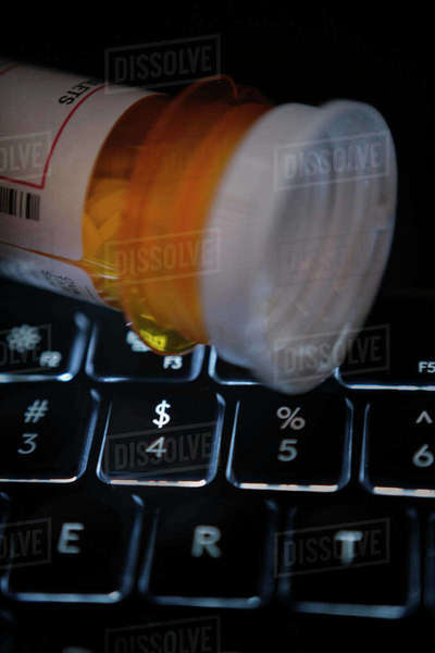 Pill bottle on computer keyboard - Royalty-free Stock Photo | Dissolve