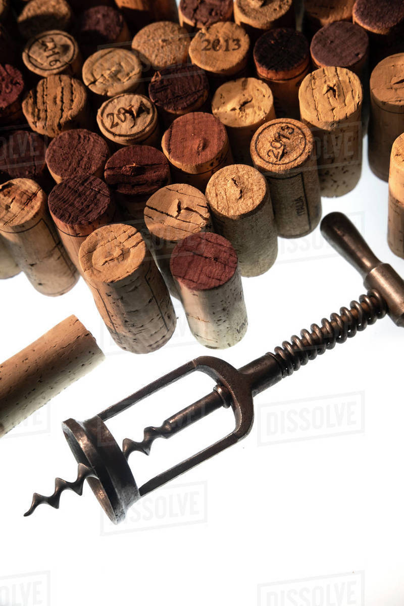 Corkscrew and collection of corks - Stock Photo - Dissolve