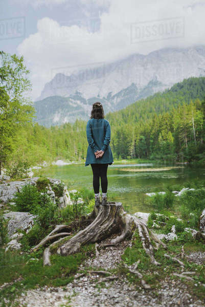 Germany, Bavaria, Eibsee, Young woman standing on stump by Frillensee ...