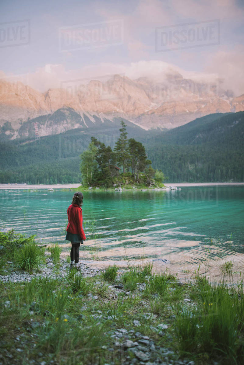 Germany, Bavaria, Eibsee, Young woman standing at shore of Eibsee lake ...