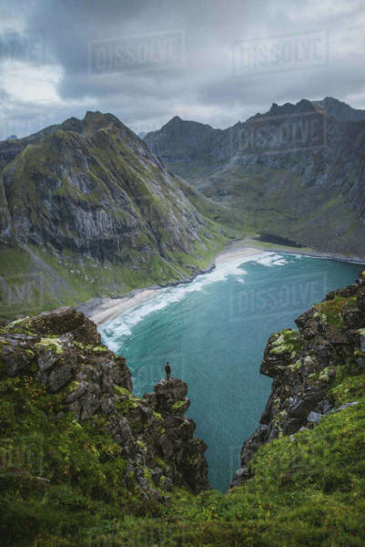 Man standing on cliff at Ryten mountain in Lofoten Islands, Norway ...