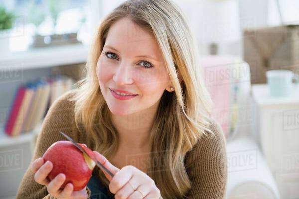 Woman peeling apple - Royalty-free Stock Photo | Dissolve