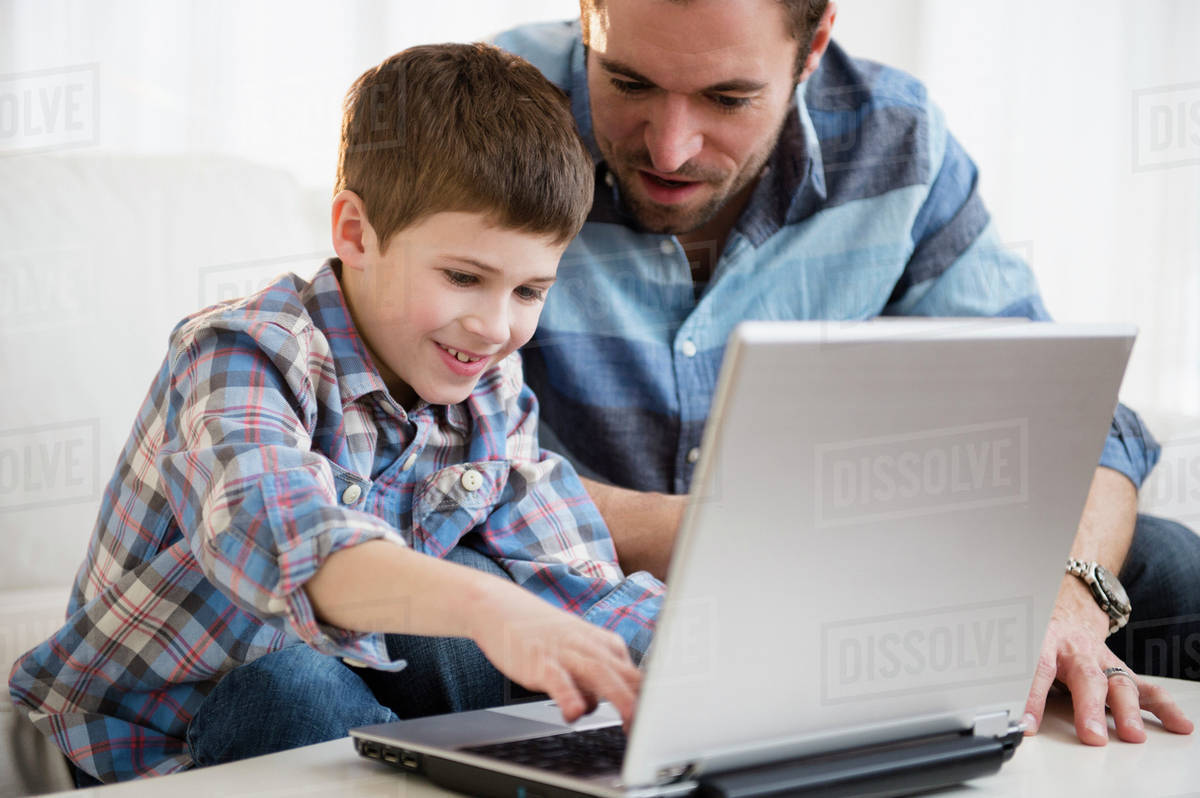 Father working on laptop with his son (8-9) - Royalty-free Stock Photo ...