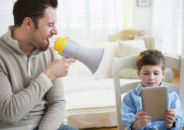 Father yelling into megaphone to discipline son (8-9) - Royalty-free ...