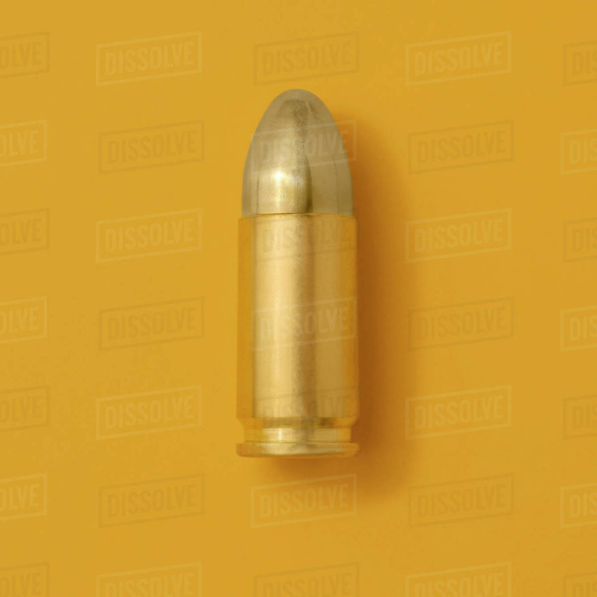 Gold bullet on yellow background - Stock Photo - Dissolve