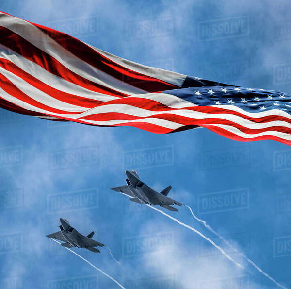 American flag blowing in wind and Lockheed Martin F-22 Raptors flying ...