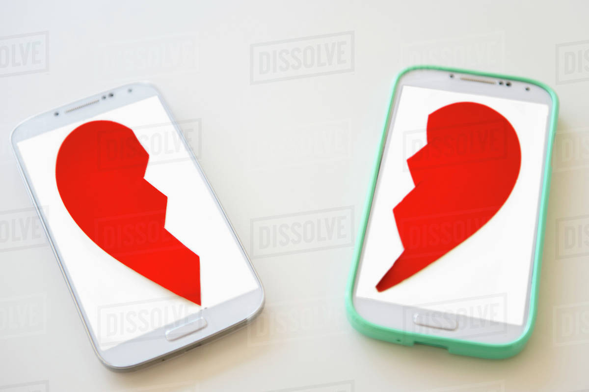 Studio shot of smart phones with broken heart on screen - Royalty-free ...