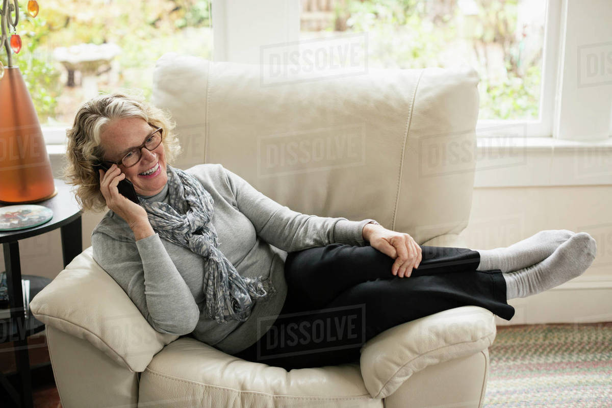 Relaxed senior woman sitting on chair talking on mobile - Royalty-free ...