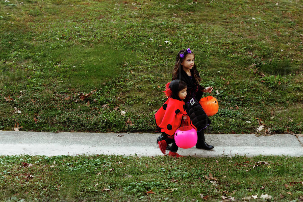 Two girls in fancy dress costumes walking down path - Royalty-free ...