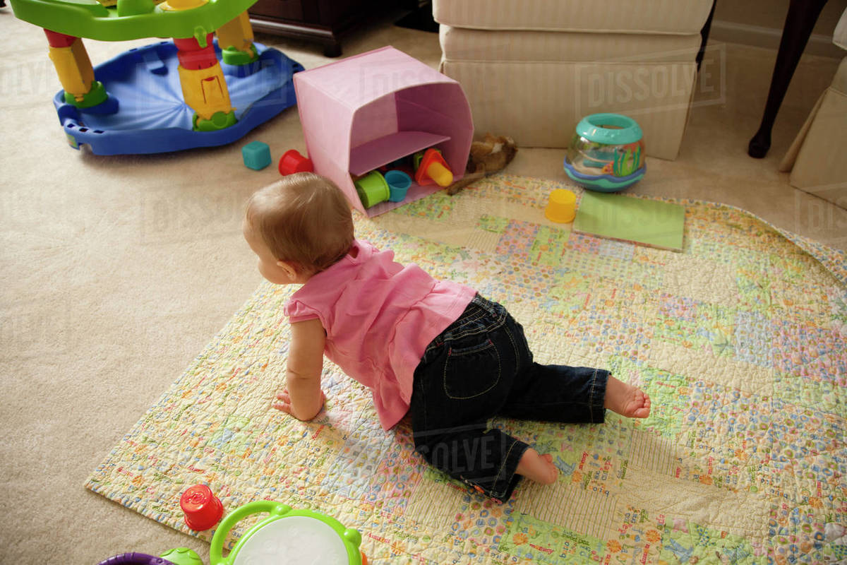 Baby girl, crawling towards toys, rear view, elevated view - Stock ...