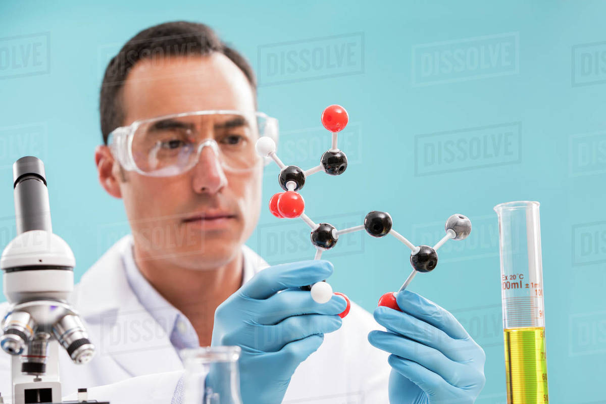 Scientist holding molecule model - Stock Photo - Dissolve