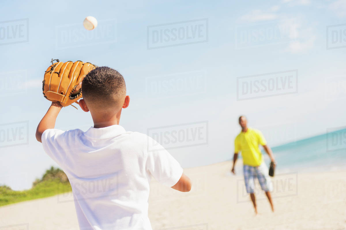 Father and son (10-11) playing baseball on beach - Royalty-free Stock ...