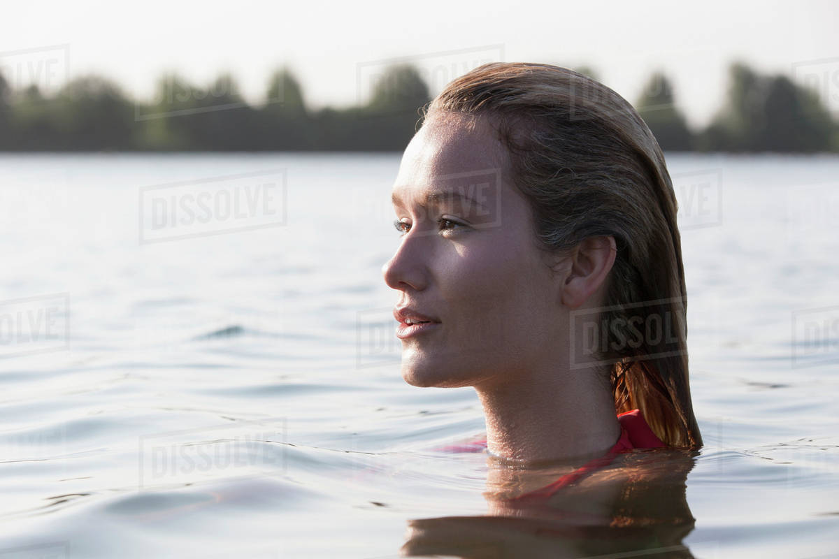 Woman relaxing in lake, Profile - Stock Photo - Dissolve