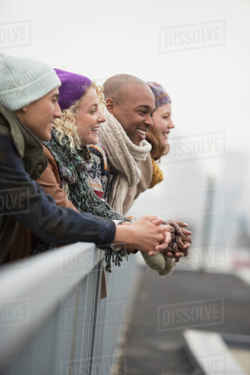 Friends standing on bridge and laughing - Stock Photo - Dissolve
