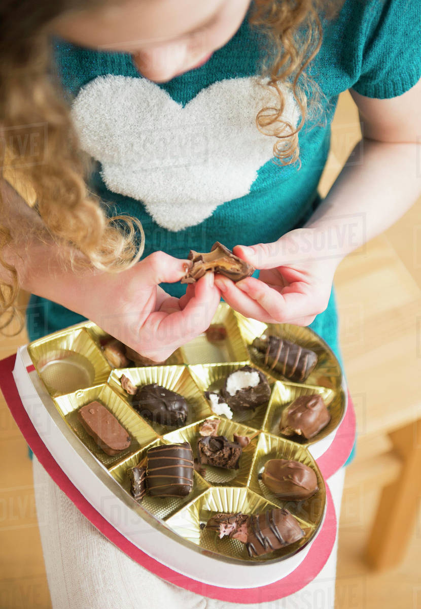 Girl (10-11) taking chocolate - Royalty-free Stock Photo | Dissolve