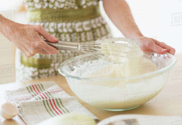 Midsection of woman whisking batter - Royalty-free Stock Photo | Dissolve