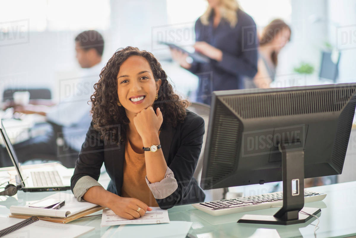 Woman smiling in office - Royalty-free Stock Photo | Dissolve