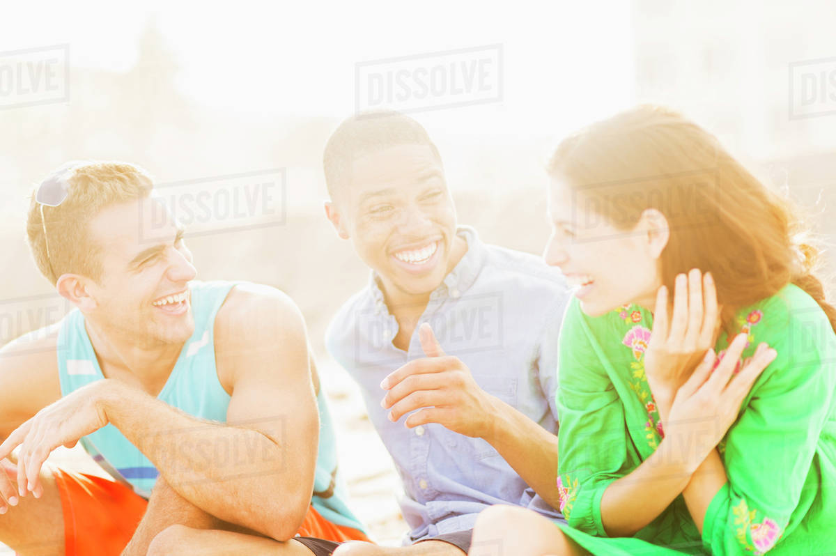 Young people talking and laughing outdoors - Stock Photo - Dissolve