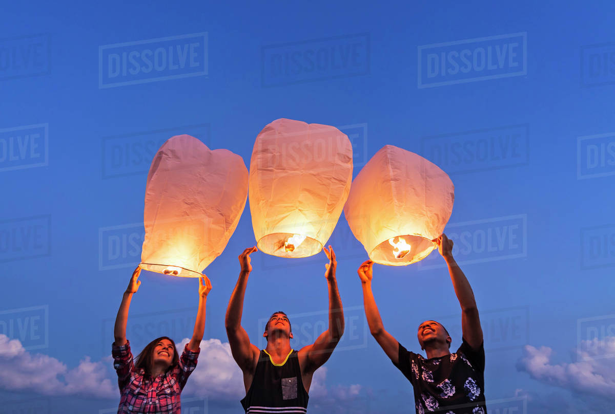 Young people with illuminated lanterns at sunset - Royalty-free Stock ...