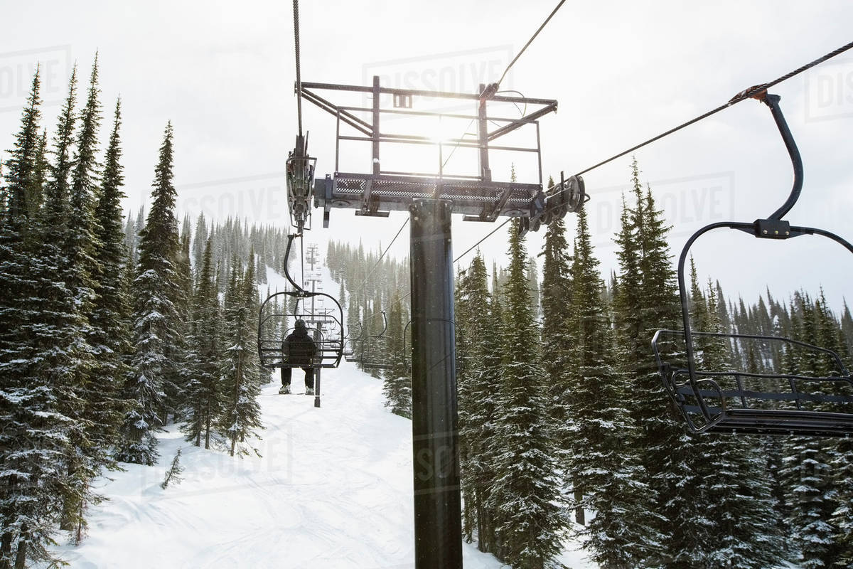Man in ski lift, rear view - Royalty-free Stock Photo | Dissolve