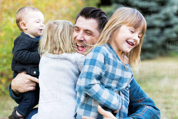 Happy family with tree children (6-11 months, 2-3, 4-5) playing in park ...