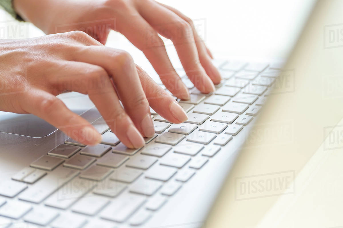 Hands typing on laptop keyboard - Stock Photo - Dissolve