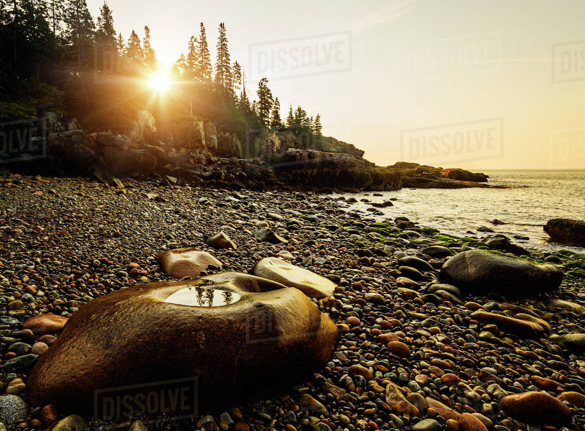 Rocks and pebbles on beach at sunrise - Royalty-free Stock Photo | Dissolve