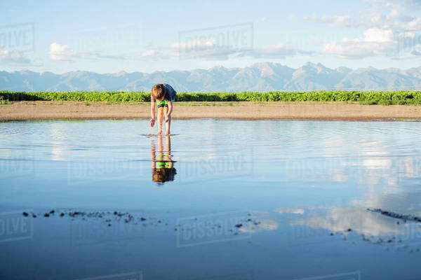 Boy (6-7) wading in water - Royalty-free Stock Photo | Dissolve