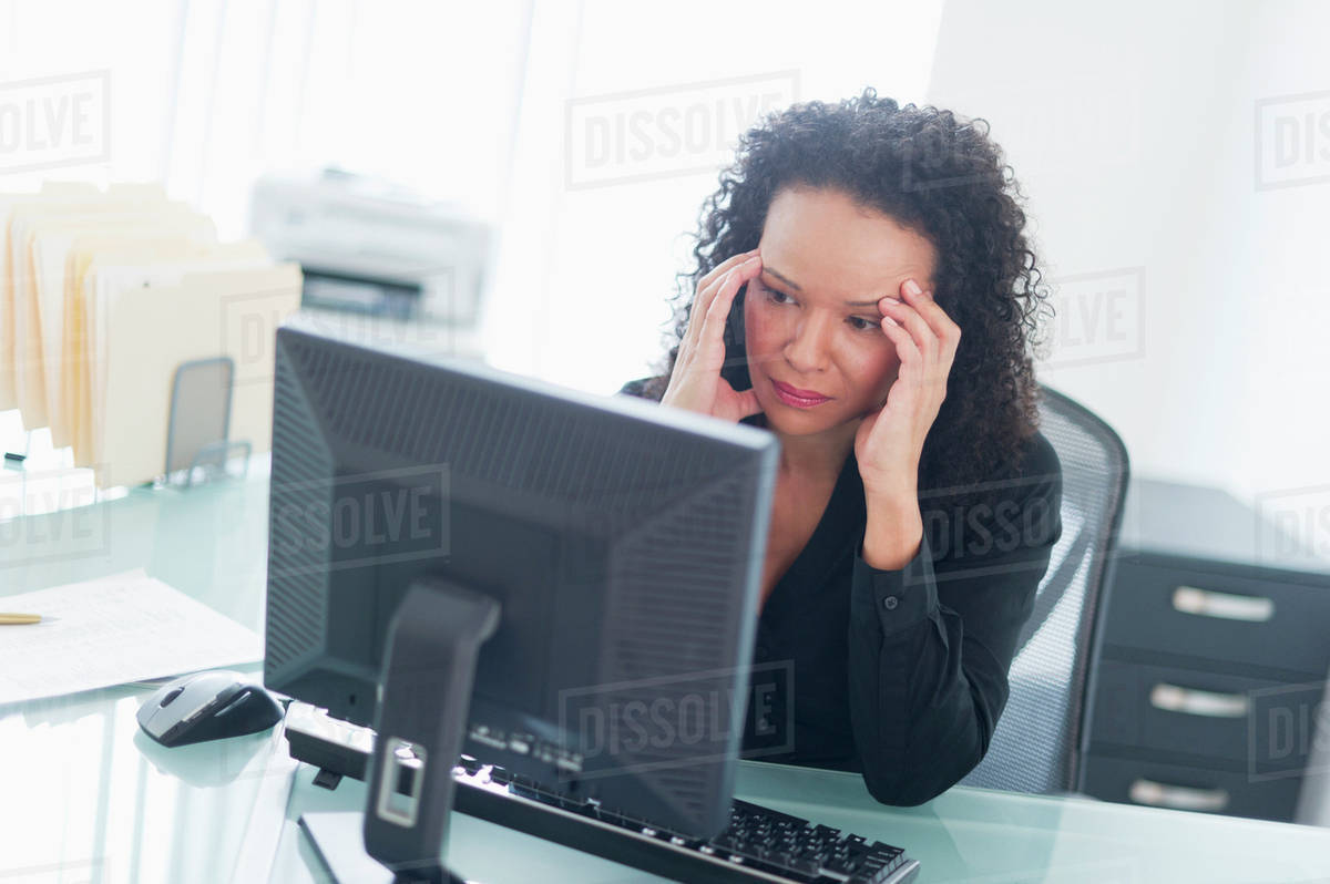 Business woman using computer holding head in hands - Royalty-free ...